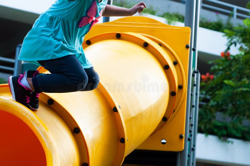 A Kid Trying To Jump from the Slide in the Playground Stock Image ...