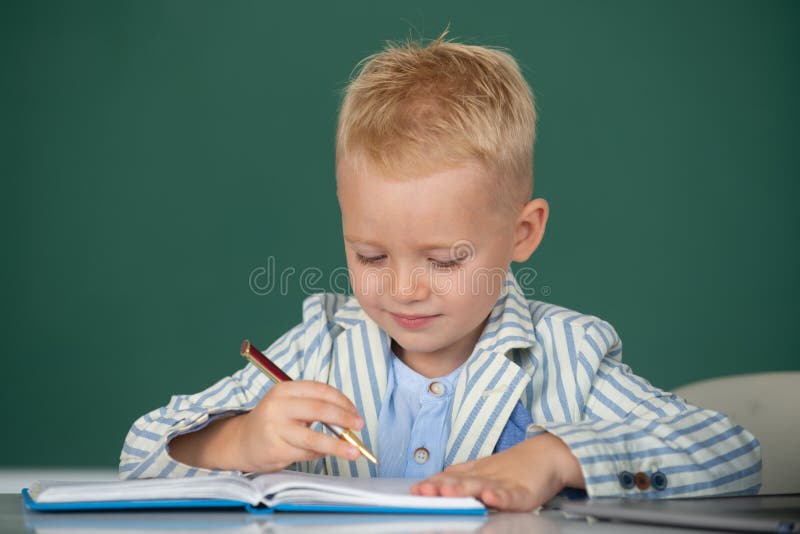 Kid Writing in Class. School Boy Studying Math on Lesson in Classroom ...