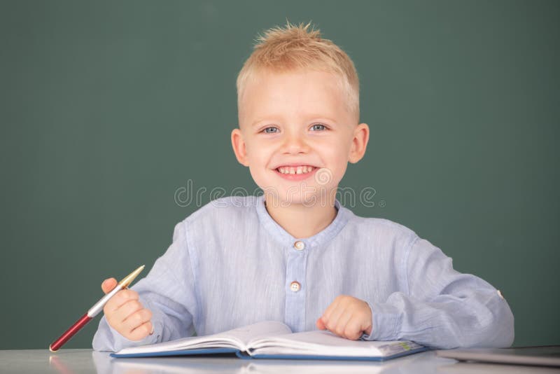 Kid Writing in Notebook in Class. Little Schoolboy Study in a Classroom ...