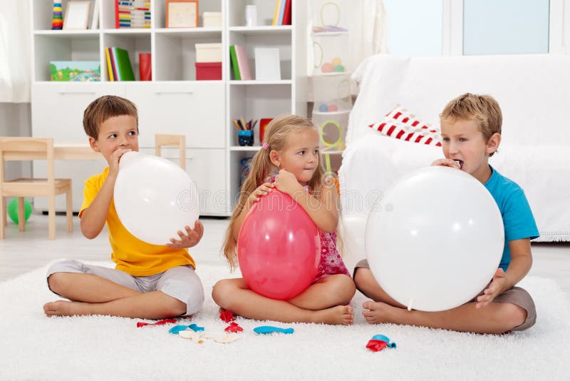 Kids blowing up balloons stock photo. Image of childhood - 23737186
