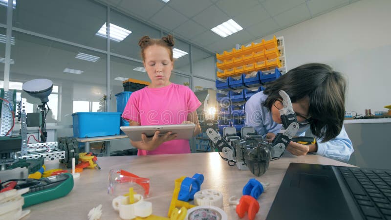 Kids Constructing a Toy Robot. Two Children Construct a Robot in a ...