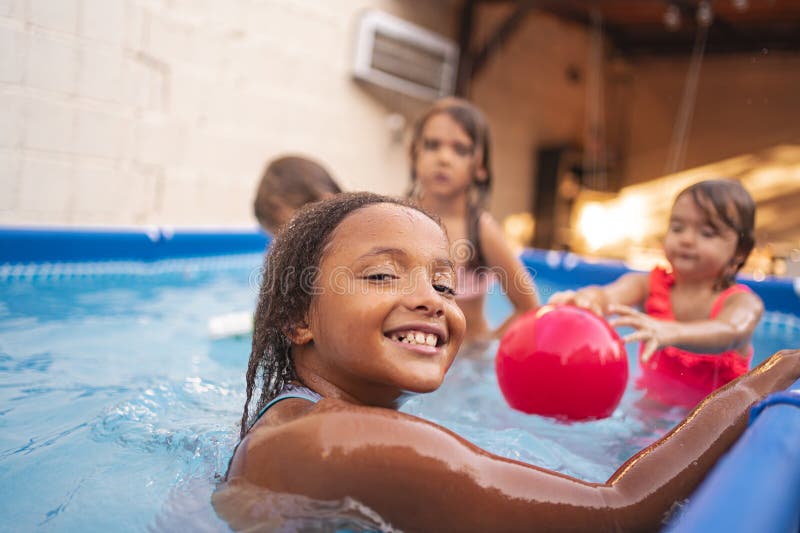 Kids are Happily Swimming and Playing with a Red Ball in the Pool Stock ...