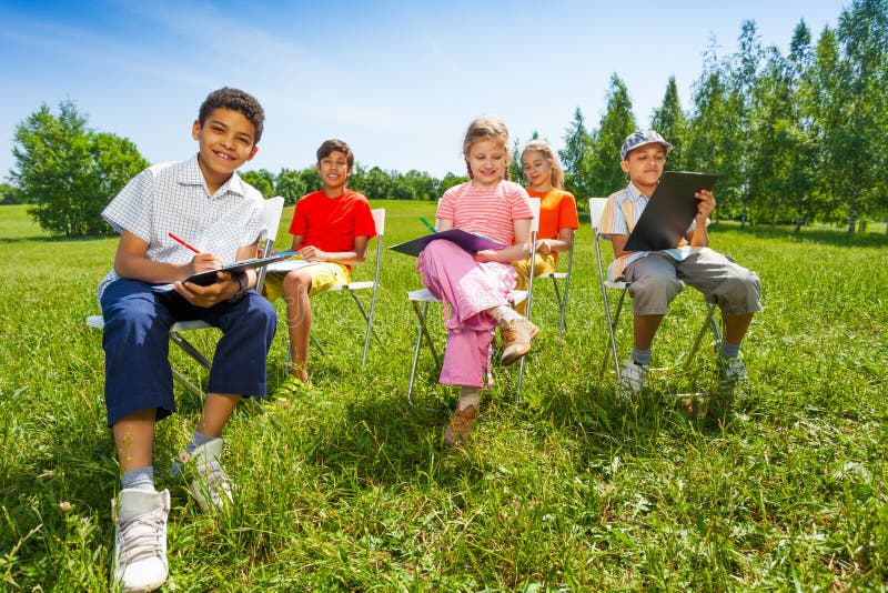 Kids Hold Sketch-boards and Sit Outside on Chairs Stock Photo - Image ...
