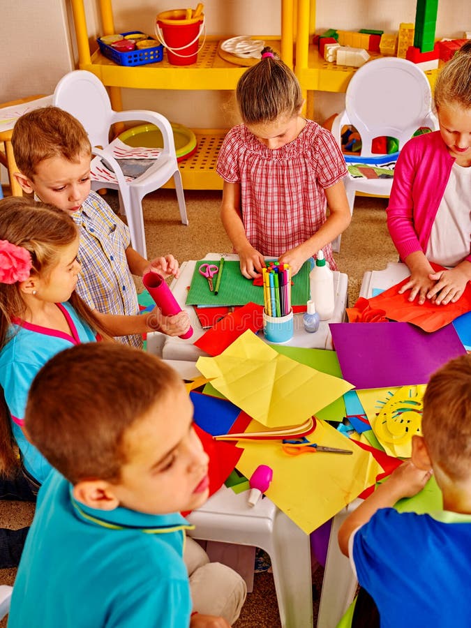 Kids Holding Colored Paper on Table in Stock Photo - Image of hand ...
