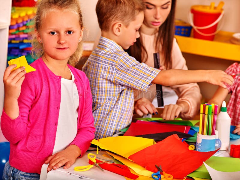 Kids Holding Colored Paper on Table in Stock Photo - Image of creative ...