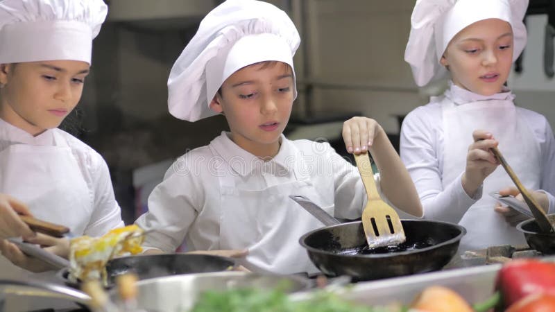 Kids Learning How To Cook Eggs in a Cooking Class in Restaurant Kitchen ...