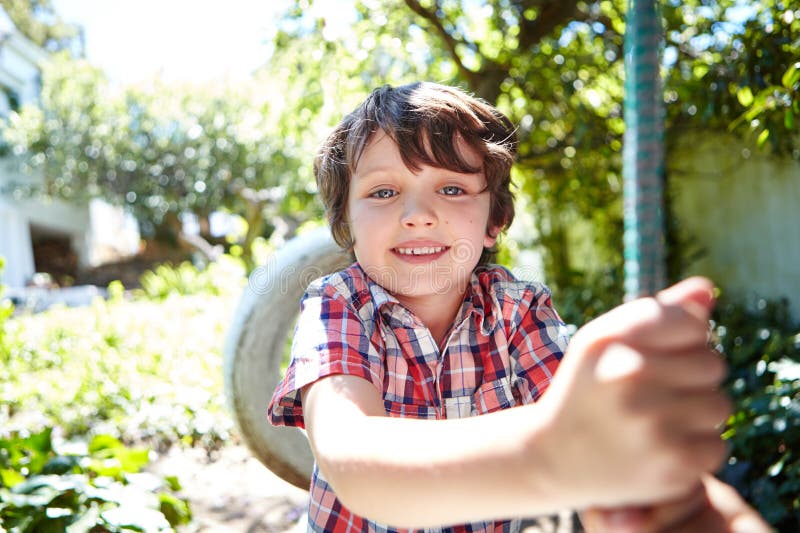 Kids Make the World Awesome. a Young Boy Swinging in the Yard. Stock ...