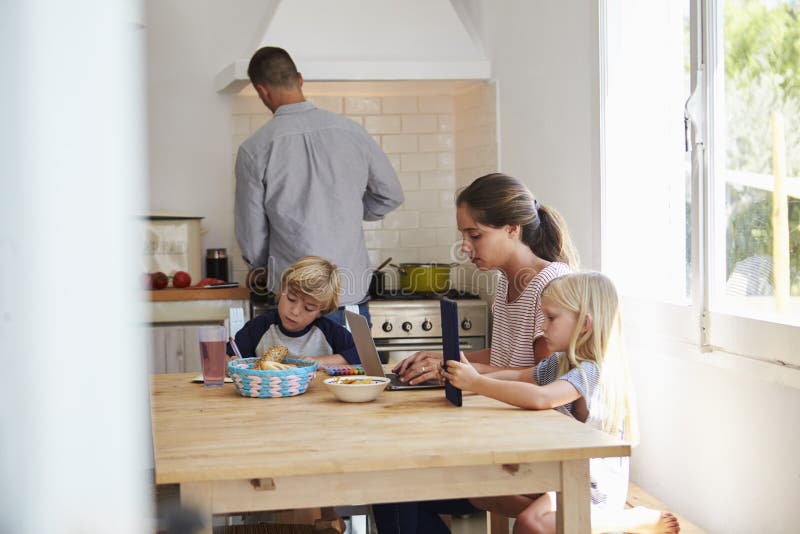 Kids and Mum at Table, Dad Cooking, Three Quarter Length Stock Photo ...