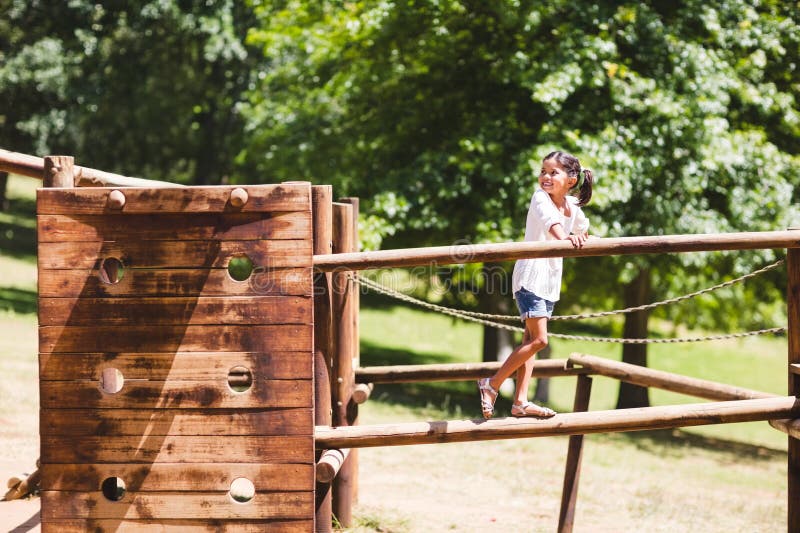 Child Girl Balancing on Thick Wooden Beam at Park Playground Using Rope ...