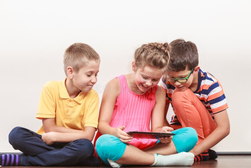 Kids playing on tablet. stock photo. Image of elementary - 75162220