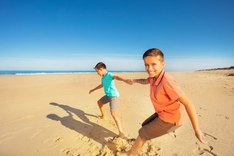 Kids Pull Each Other on the Beach Towards Sea Stock Photo - Image of ...