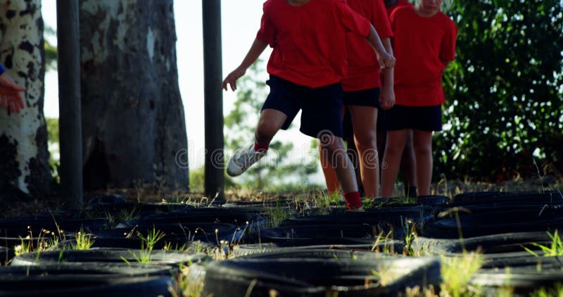 Kids Running Over Tyres during Obstacle Course Training Stock Footage ...