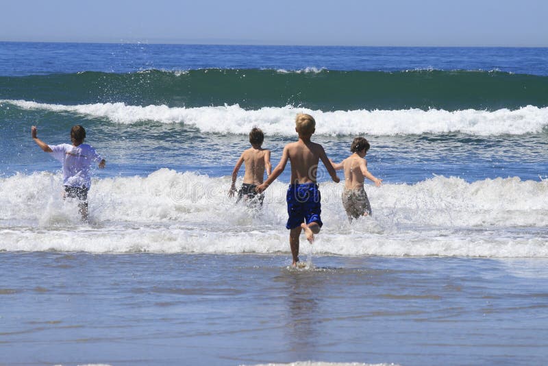 Kids running into waves stock photo. Image of excitement - 8891652