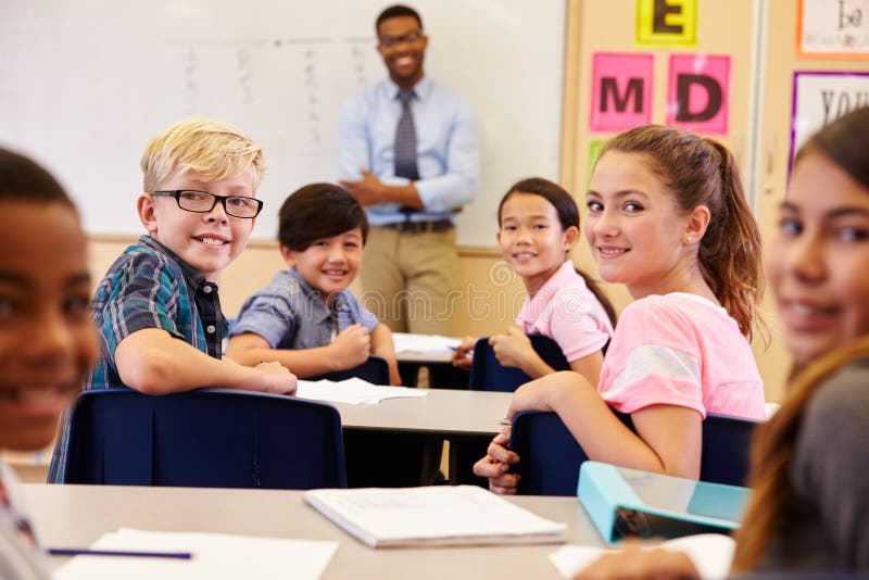 Kids at Their Desks in Classroom Turning To Face the Camera Stock Image ...