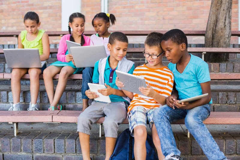 Kids Using Digital Tablet and Laptop on Bench Stock Image - Image of ...