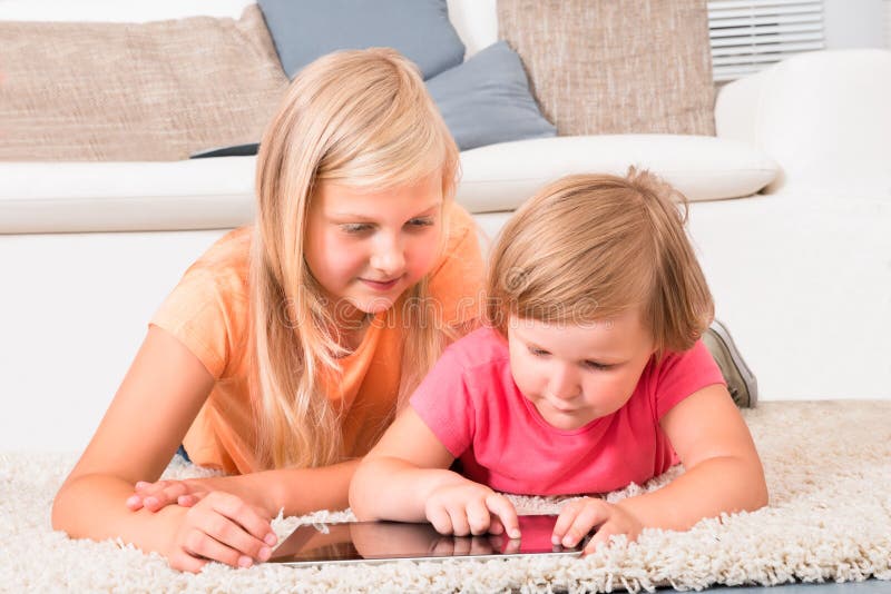 Kids Using Tablet Lying On Carpet Stock Photo - Image of public, tablet ...