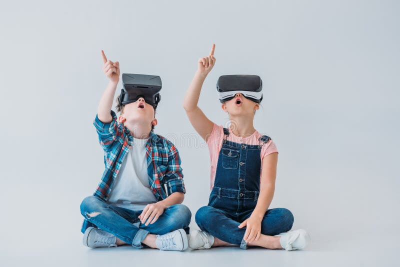Kids Using Virtual Reality Headsets and Pointing Up with Finger while ...