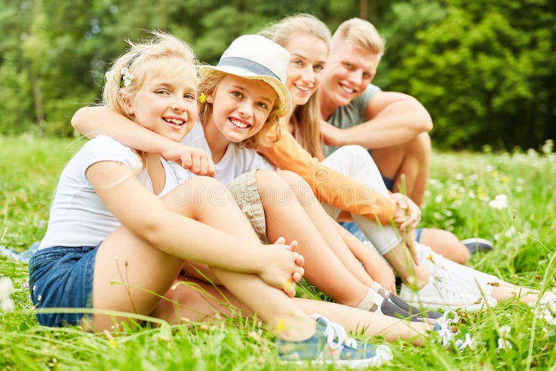 Kinder Und Eltern Sitzen Entspanntes Im Gras Stockfoto - Bild von kind ...