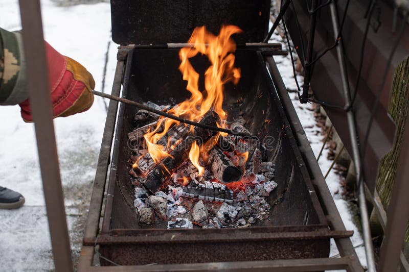 Kindling a Fire in the Barbecue, Turning Over Burning Coals Stock Photo ...