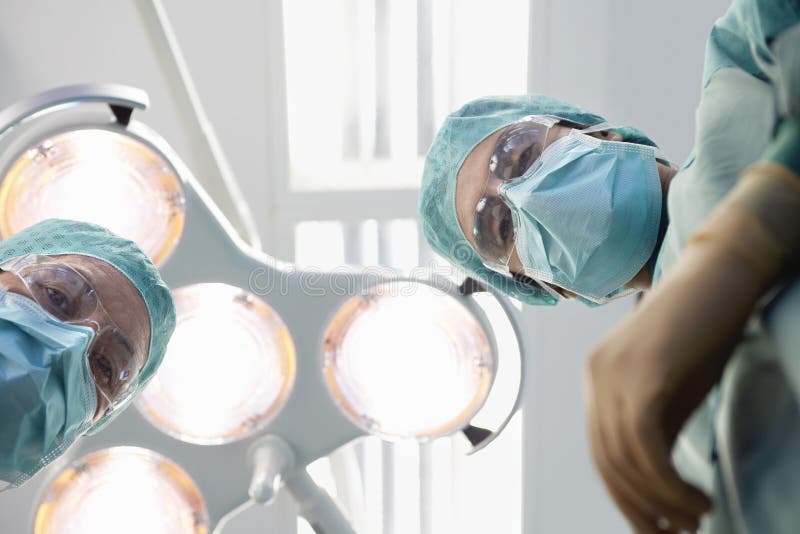 Kirurger Under Kirurgiljus I Operationssal Fotografering för Bildbyråer ...