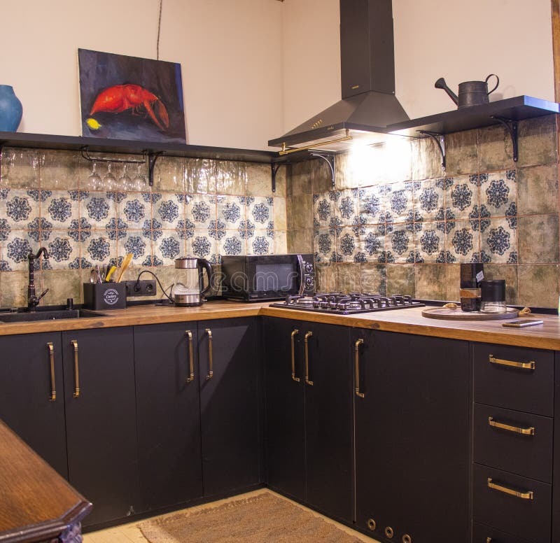 A Kitchen with Blue and White Tile on the Walls, an Open Cupboard Door ...
