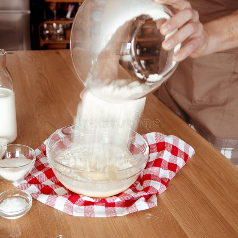 Kitchen. the Cook Pours the Flour from the Glass Bowl into the Dough ...