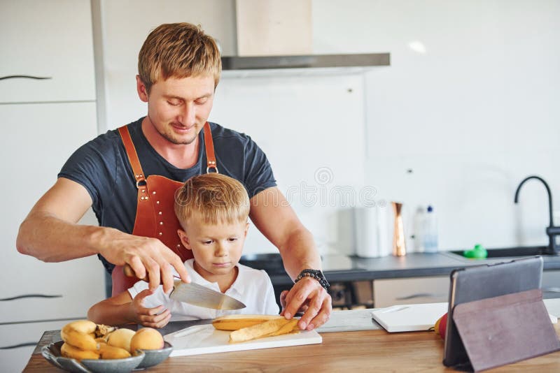 Learning How To Cook. Father and Son is Indoors at Home Together Stock ...