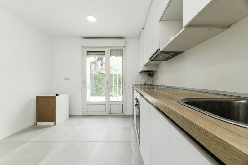 Kitchen in a House with an Oak-colored Wooden Countertop and an Exit ...