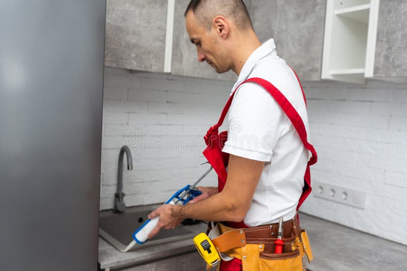 Kitchen Installation Man. Worker Assembling Furniture Cabinet Hinge ...