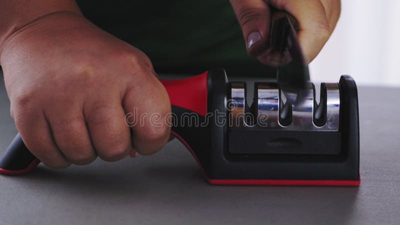 A Kitchen Knife in the Cook S Hand is Sharpened in a Special Knife ...
