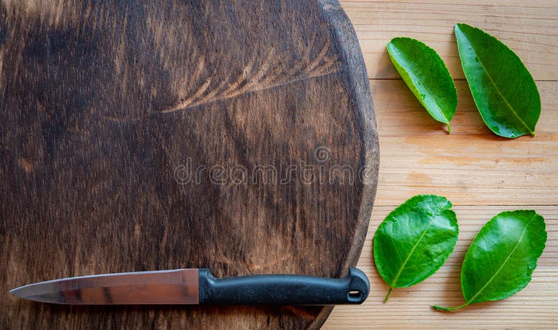 Kitchen Knife and Green Lemon Leaf on Wood Cutting Board Stock Image ...
