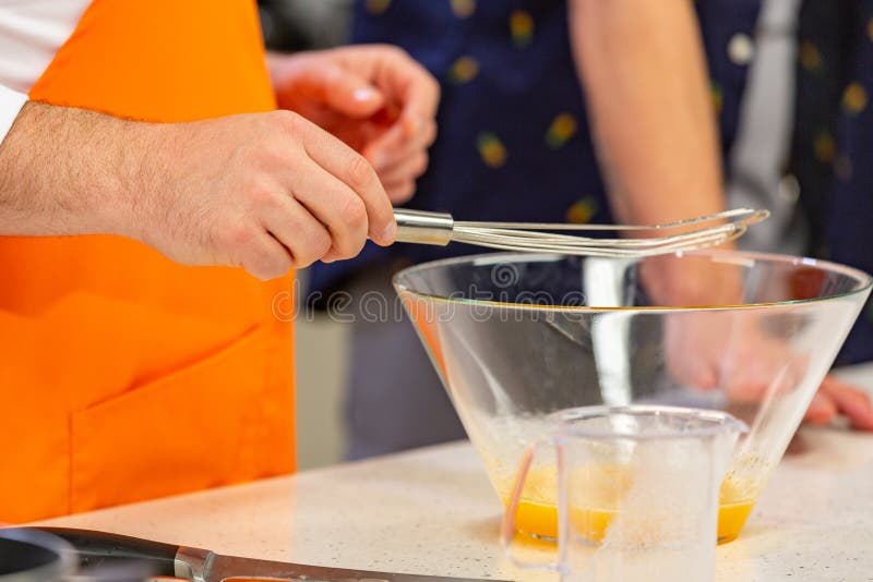 Kitchen Preparation: the Chef Beating Eggs in a Bowl with a Whisk ...