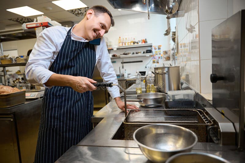 Kitchen Worker Communicates on a Mobile Phone Stock Photo - Image of ...
