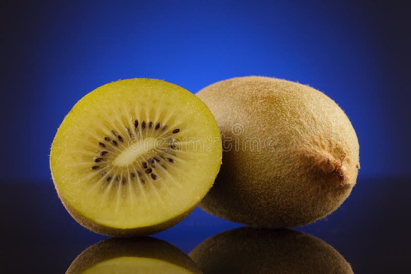 Kiwi y una mitad en azul imagen de archivo. Imagen de sano - 11740161