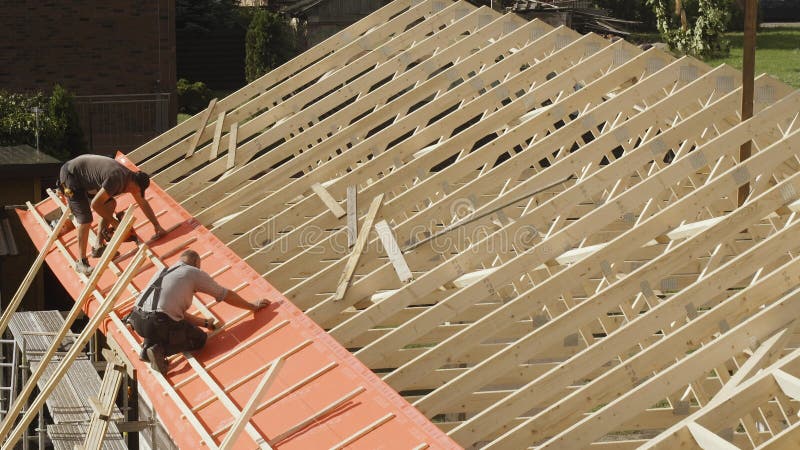 Workers Perform Installation Roofing Work on the Roof of the House ...