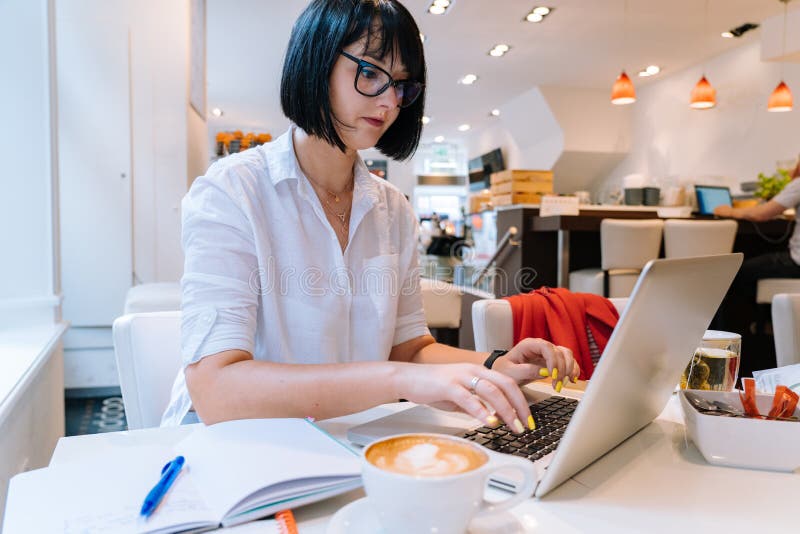 Junge Frau Im Büro Arbeitet Mit Und Tippt Ihren Laptop-PC Auf Ihrem ... Junge Frau Im Büro Arbeitet Mit Und Tippt Ihren Laptop-PC Auf Ihrem ...