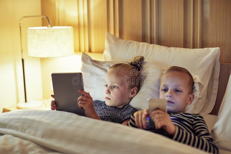 Cute Kleiner Bruder Und Schwester Schauen Videos Vor Dem Schlafengehen An Stockbild Bild Von