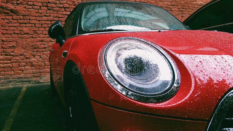 Kleines Rotes Auto Auf Einem Hintergrund Einer Backsteinmauer Stockfoto ...