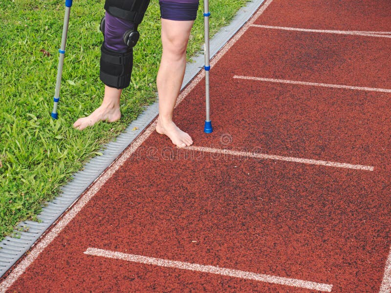 Knee with Knee Brace Support Walking with Sticks on Stadium Stock Photo ...