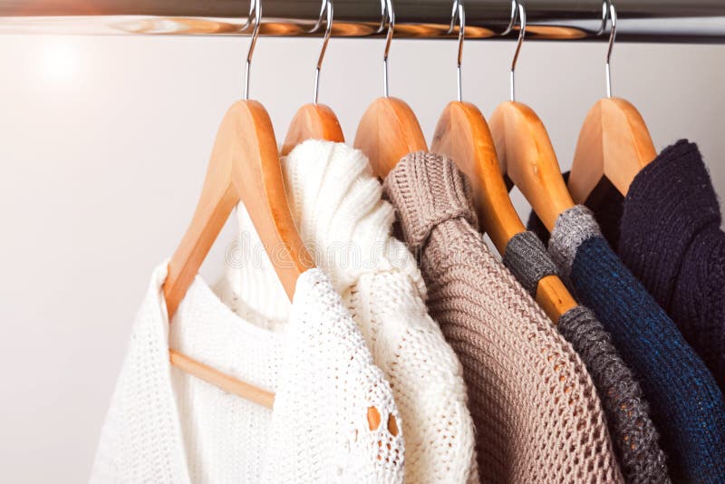 Knitted Sweaters on Hangers on the White Wall Background Stock Photo ...