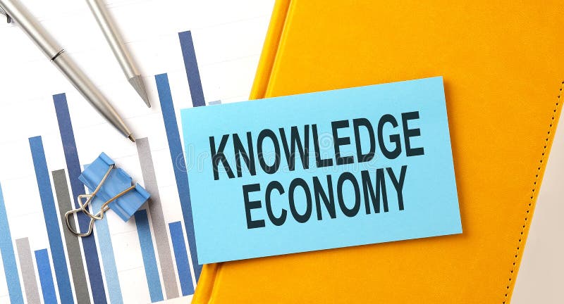 KNOWLEDGE ECONOMY Text on Sticker on the Yellow Notebook with Chart and ...