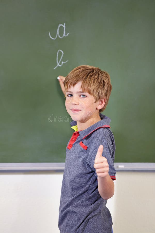 He Knows the Answer. a Young Boy Writing on the Blackboard at School ...