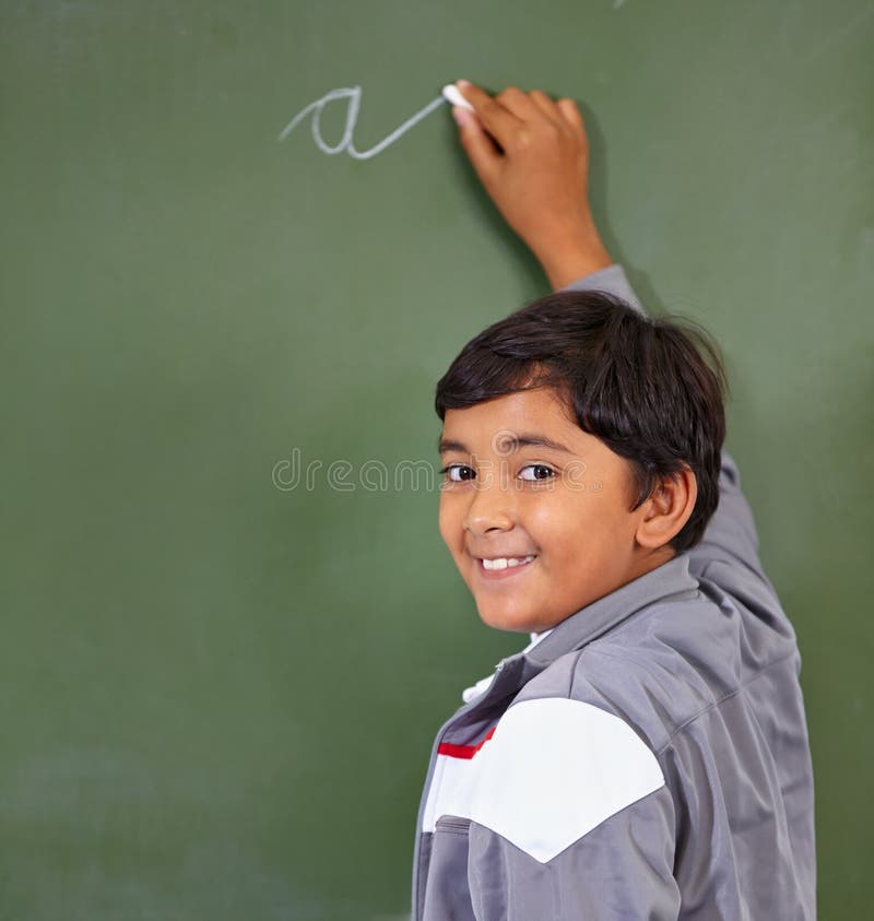 He Knows the Answer. a Young Ethnic Boy Writing on the Blackboard at ...