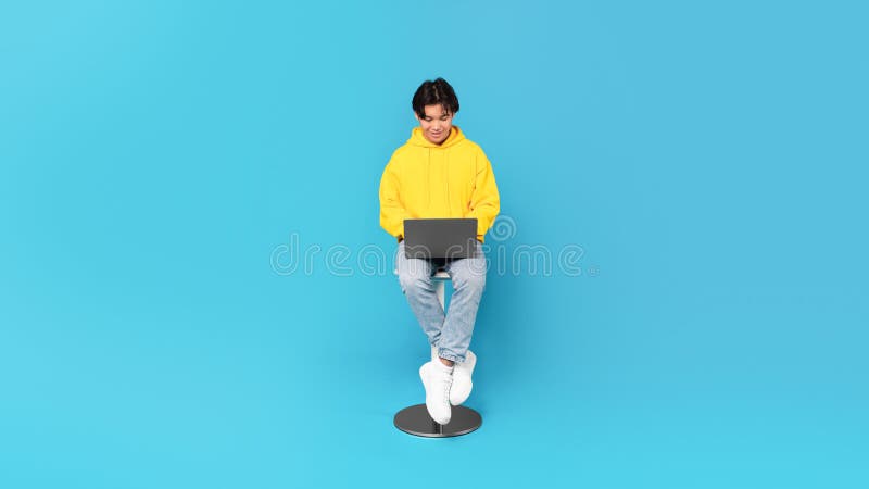 Korean Teen Guy Using Laptop Sitting Over Blue Studio Background Stock ...