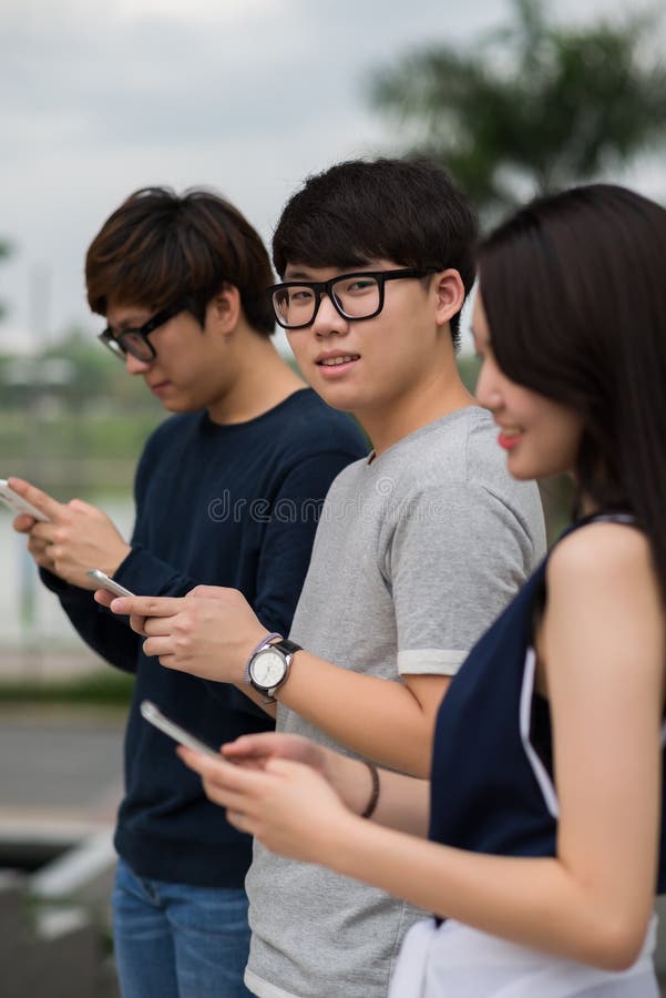 Young man with two phones stock photo. Image of sitting - 114272960