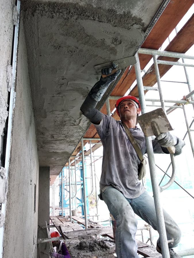 Construction Workers Plastering Wall Using Cement Plaster at the ...