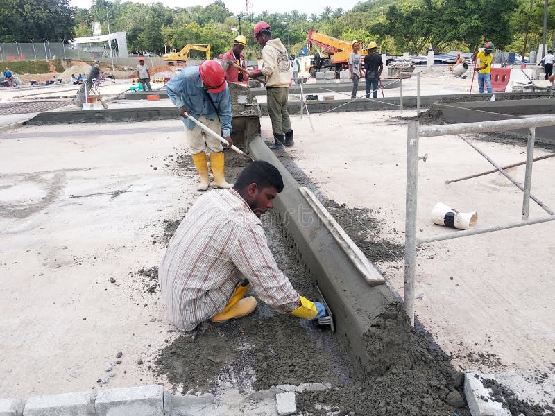 Construction Workers Creating Concrete Road Curb at the Construction ...