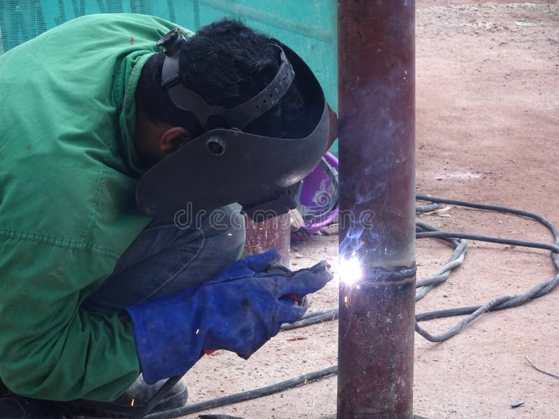 Construction Workers Welding Pipes at the Construction Site. Editorial ...