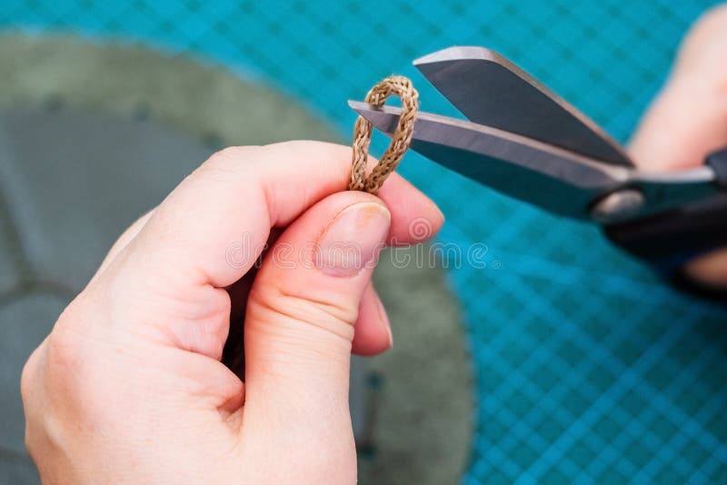 L'artisan Coupe Le Cordon Pour La Poche Par Des Ciseaux Image stock ...