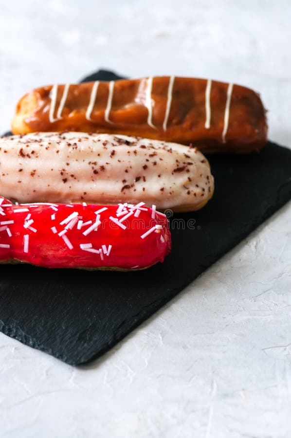 L'ensemble D'eclairs Assortis a Servi Sur Un Panneau D'ardoise Sur Une ...